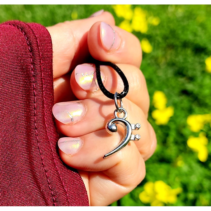 Divertido colgante de metal en forma de CLAVE de FA.Incluye cordón y caja.